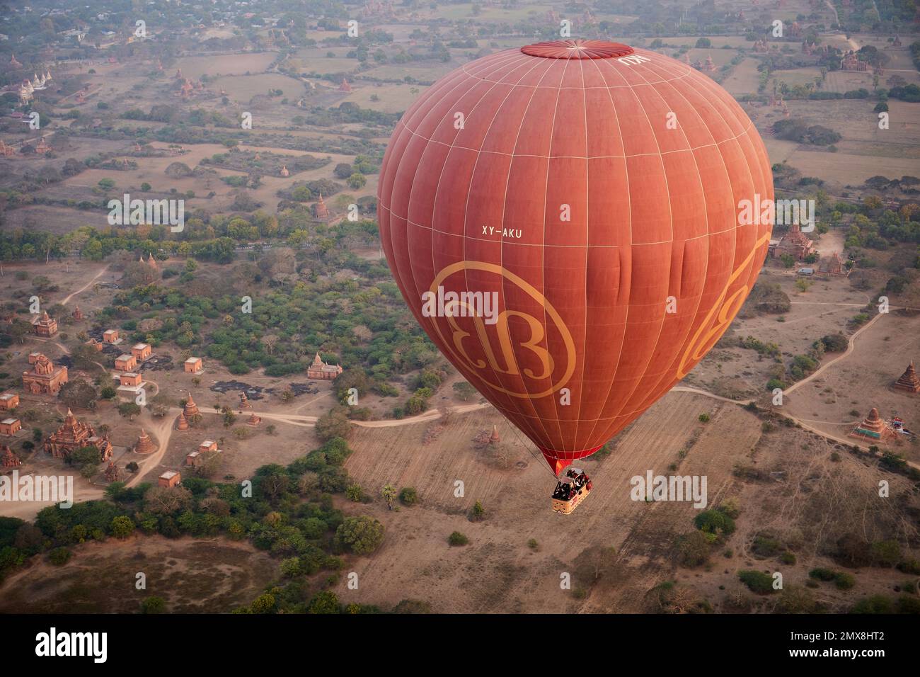 Aerial view of a single hot air balloon flying over a cluster of Shan ...
