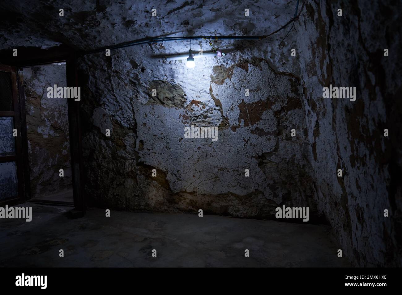 A high resolution photo of a moody dimly-lit basement hallway with a ...