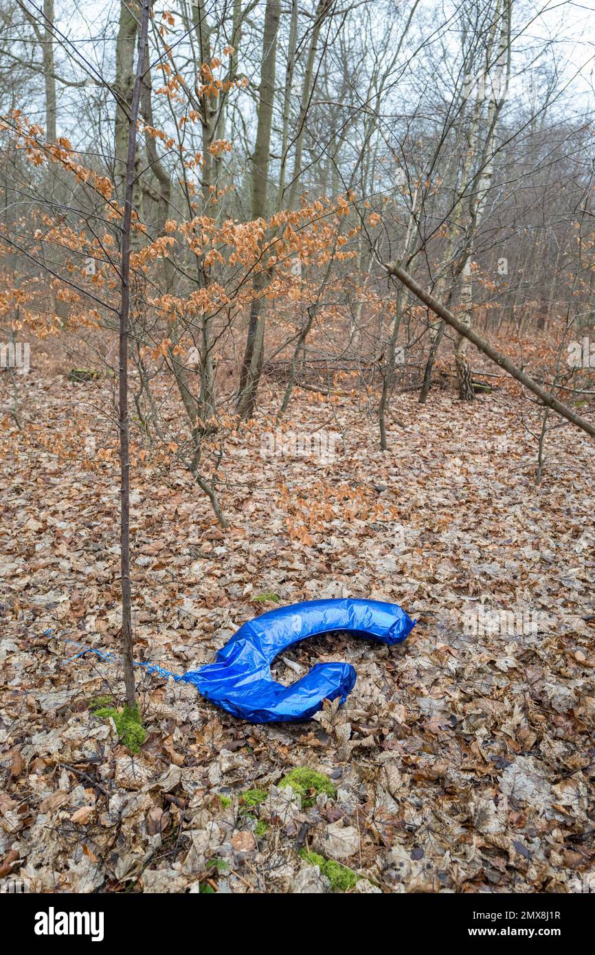 Plastic blue balloon in the shape of a number six or number nine laying ...