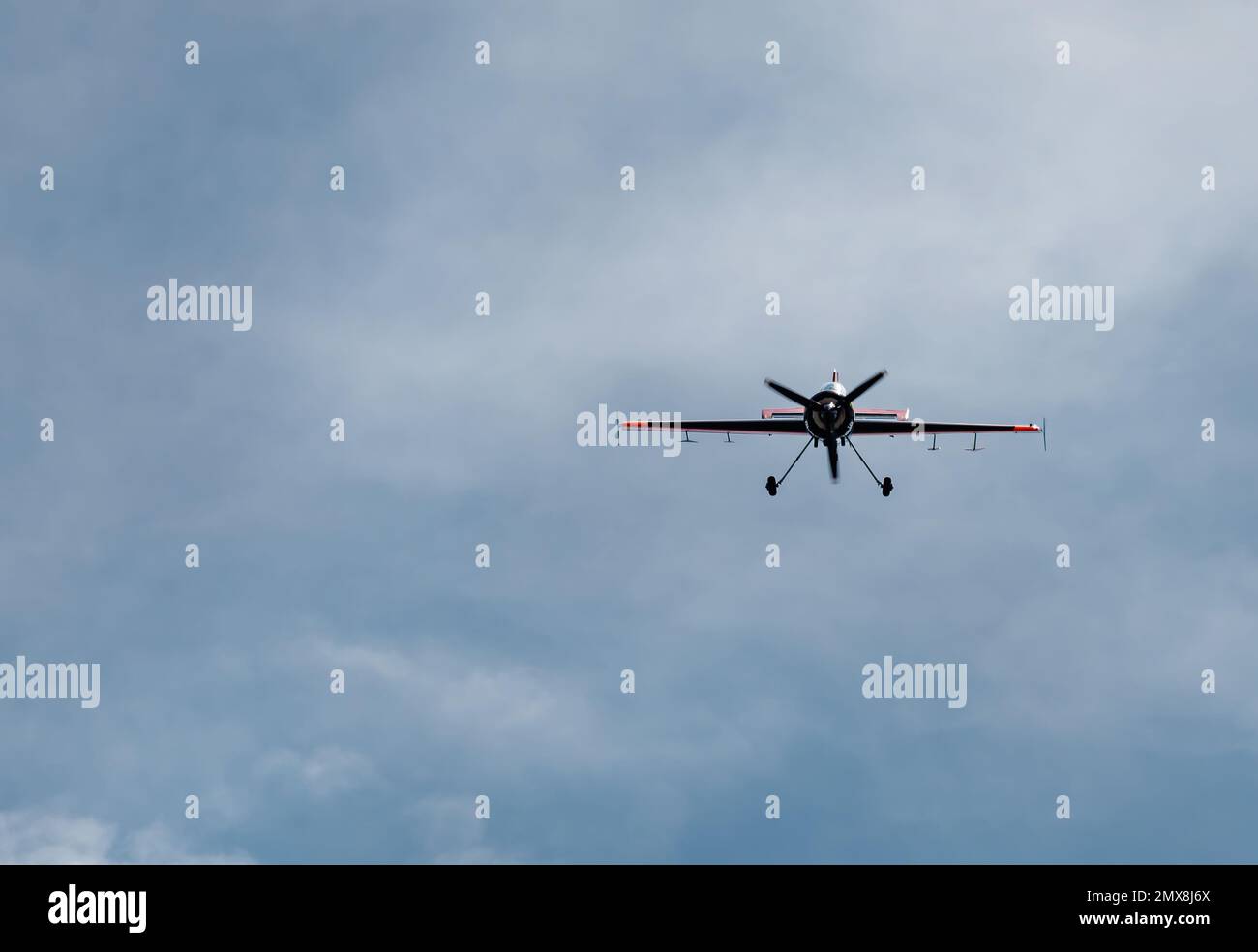 a plane flying head-on over a blue sky with white clouds. concept ...