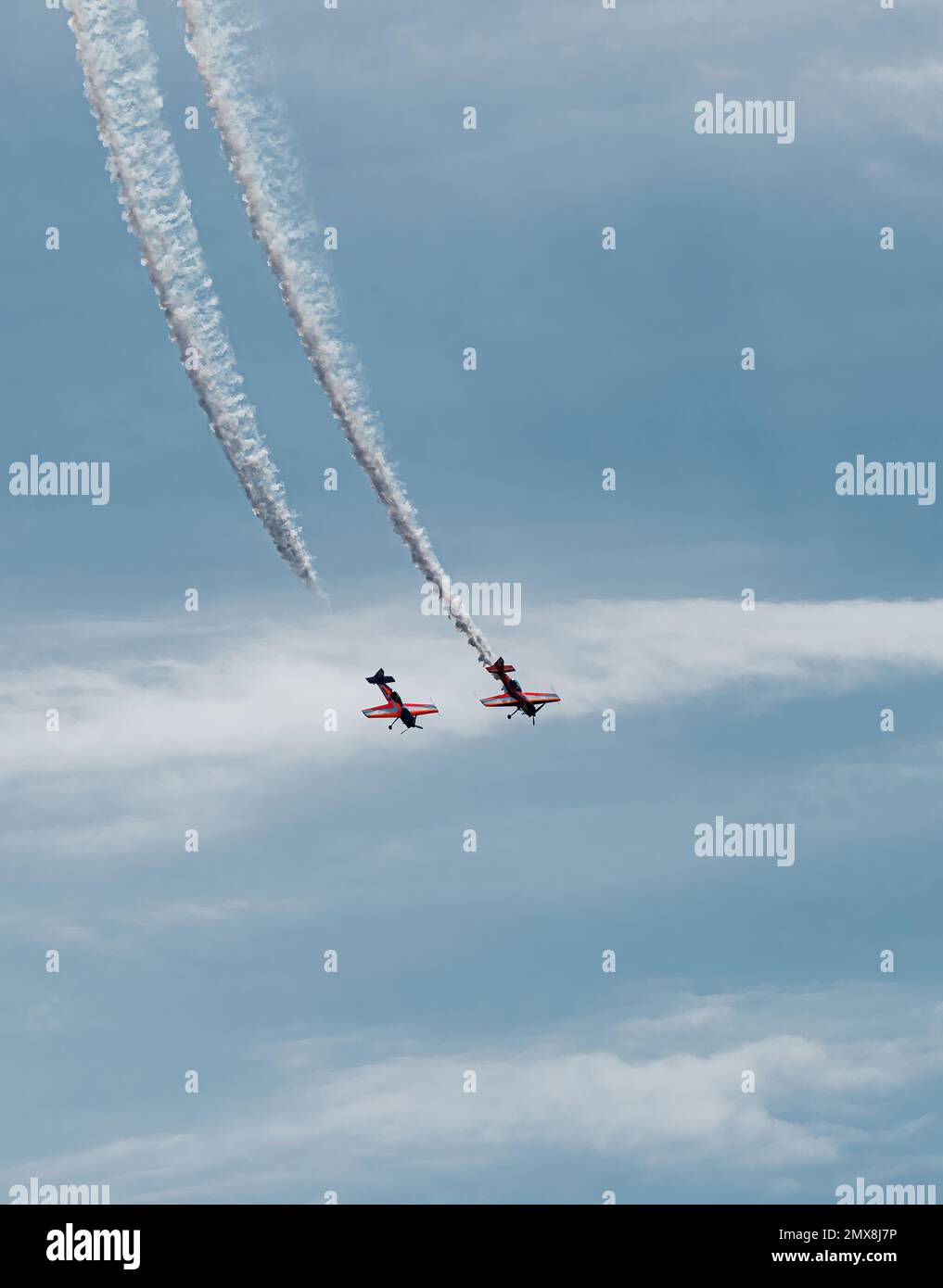 two small planes fly in parallel describing a white trajectory over the ...