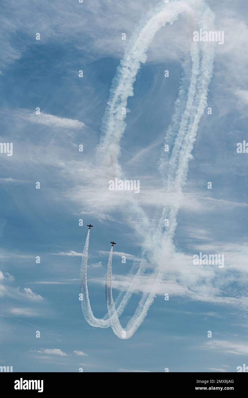 two small planes describe circular trajectories over the blue sky ...