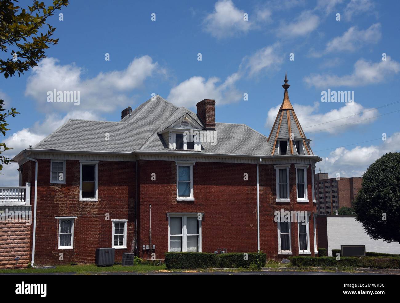 Red brick, Victorian Home, has turret with copper top and finial Stock ...