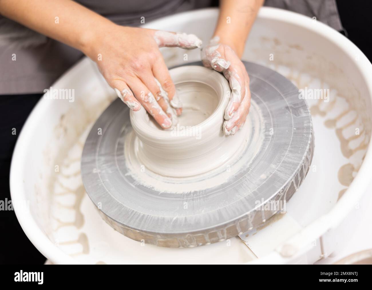 Woman potter works with potter weel, craftsman hands close up. Hands of ...