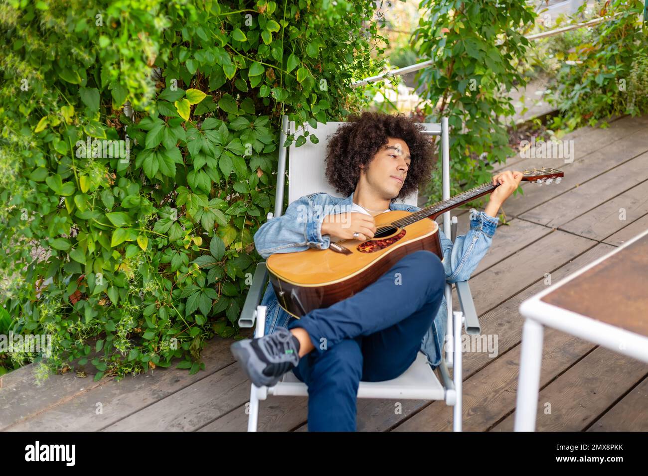 Beautiful young Afro-Italian mixed race man in casual wear playing ...