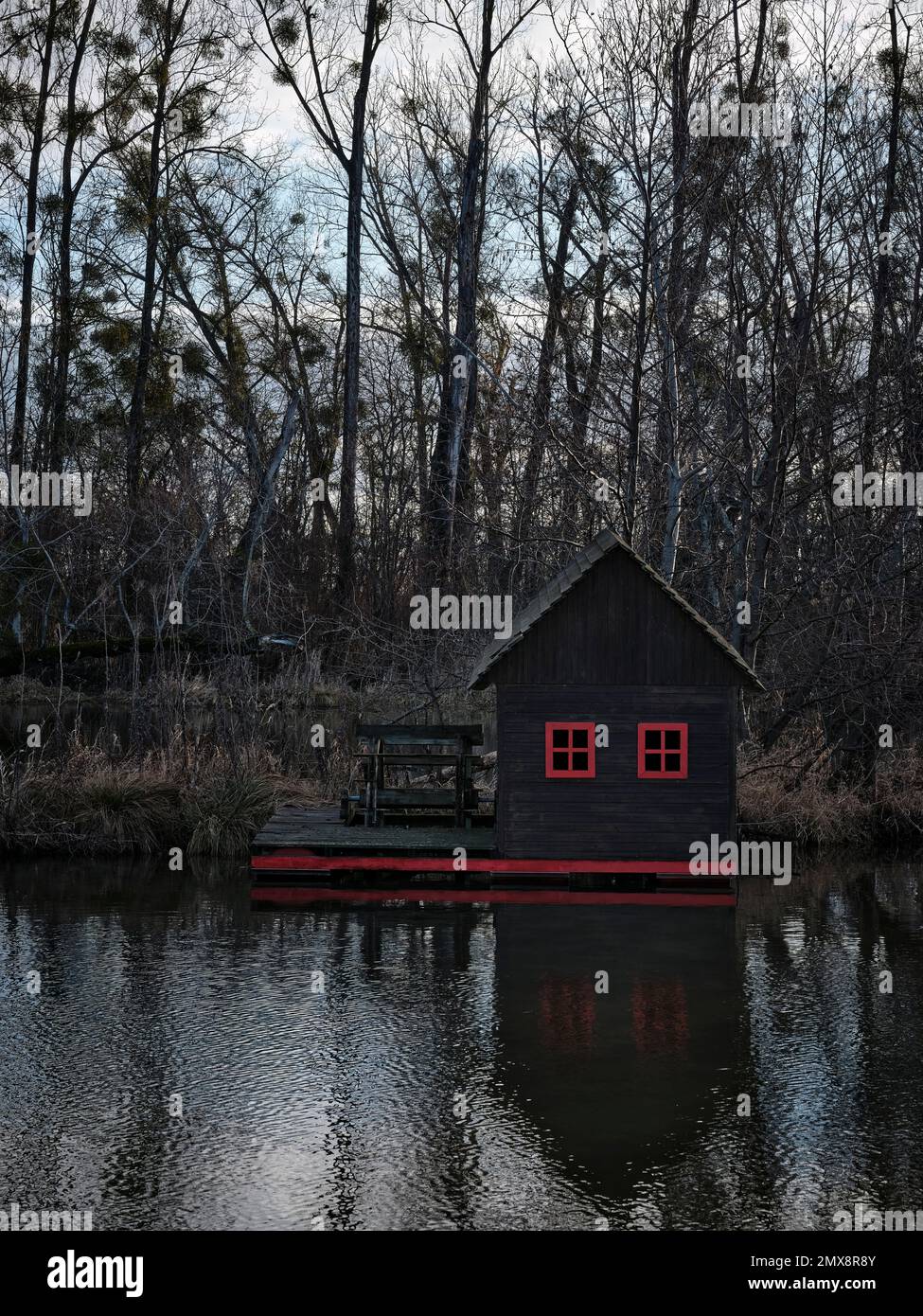 Wooden houseboat with red windows on the Little Dunaj river in the ...
