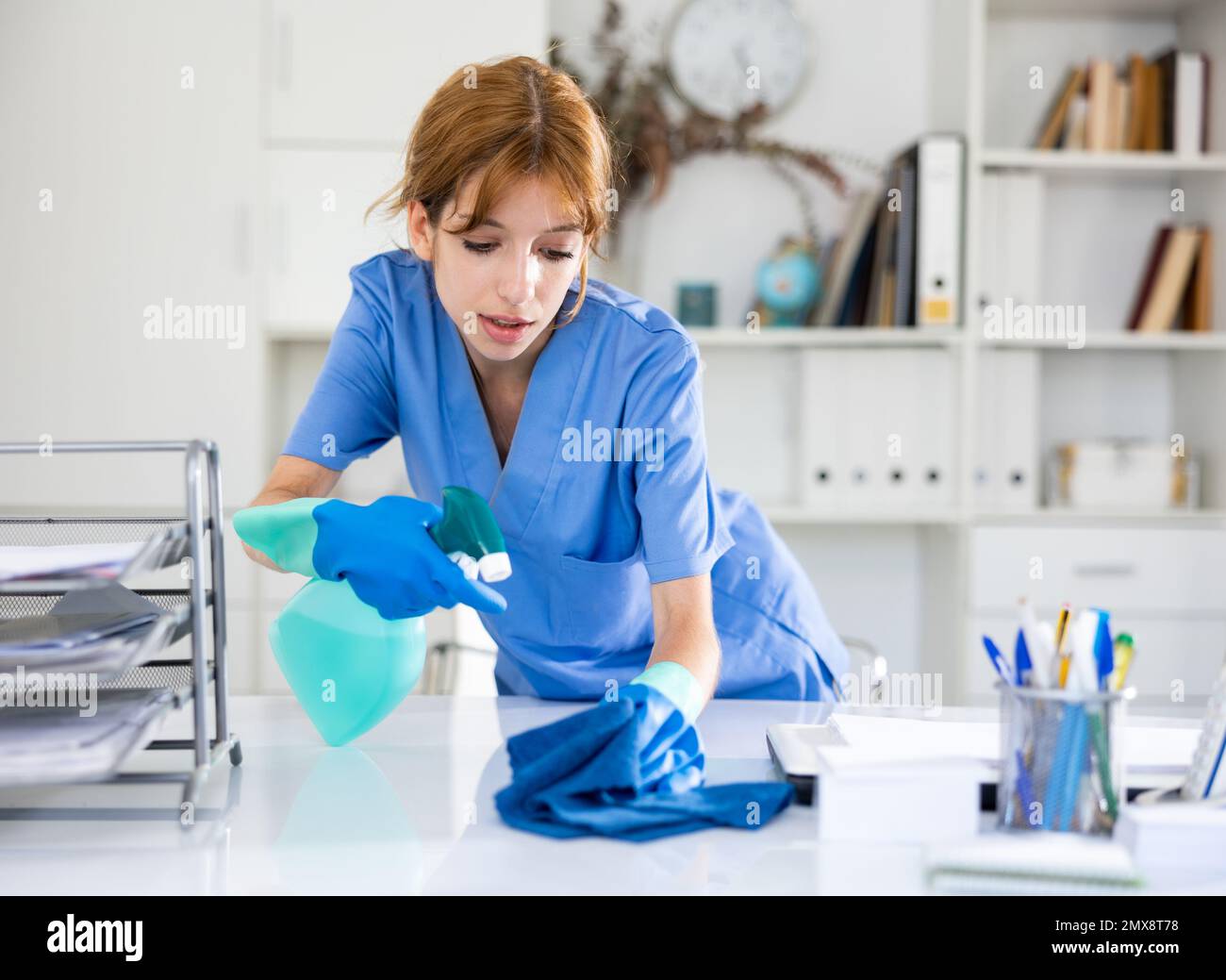 Female cleaning service worker wiping working table in office Stock ...