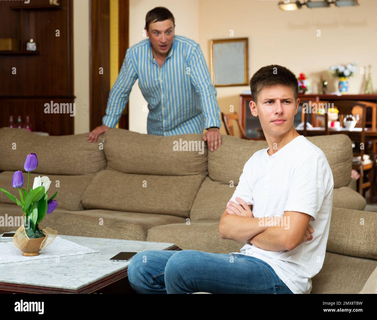 Frowning teen boy with berating father Stock Photo - Alamy
