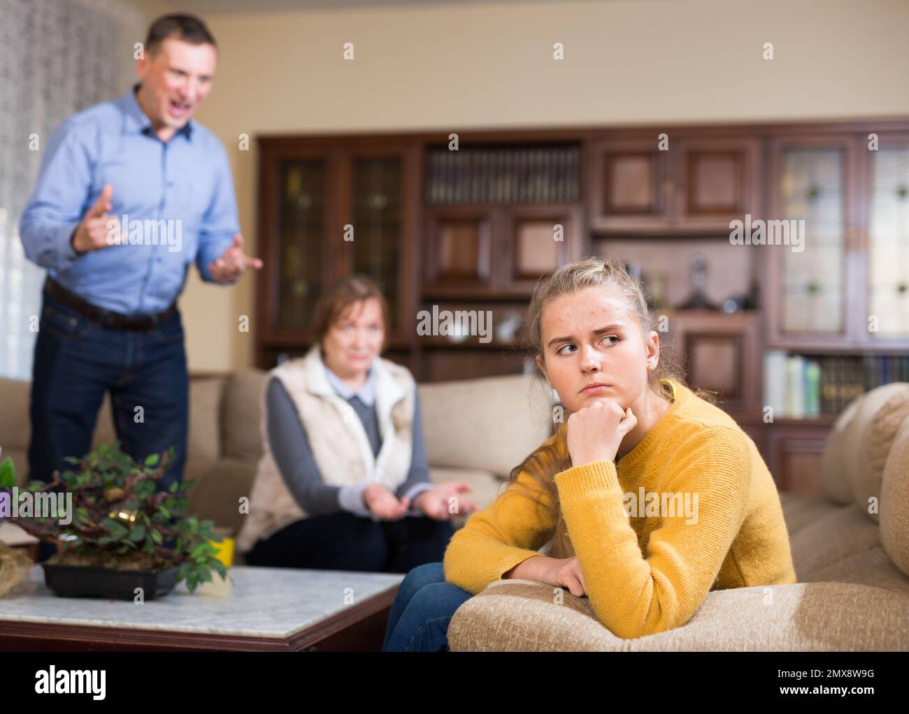 Teen girl scolded by father and grandma Stock Photo - Alamy