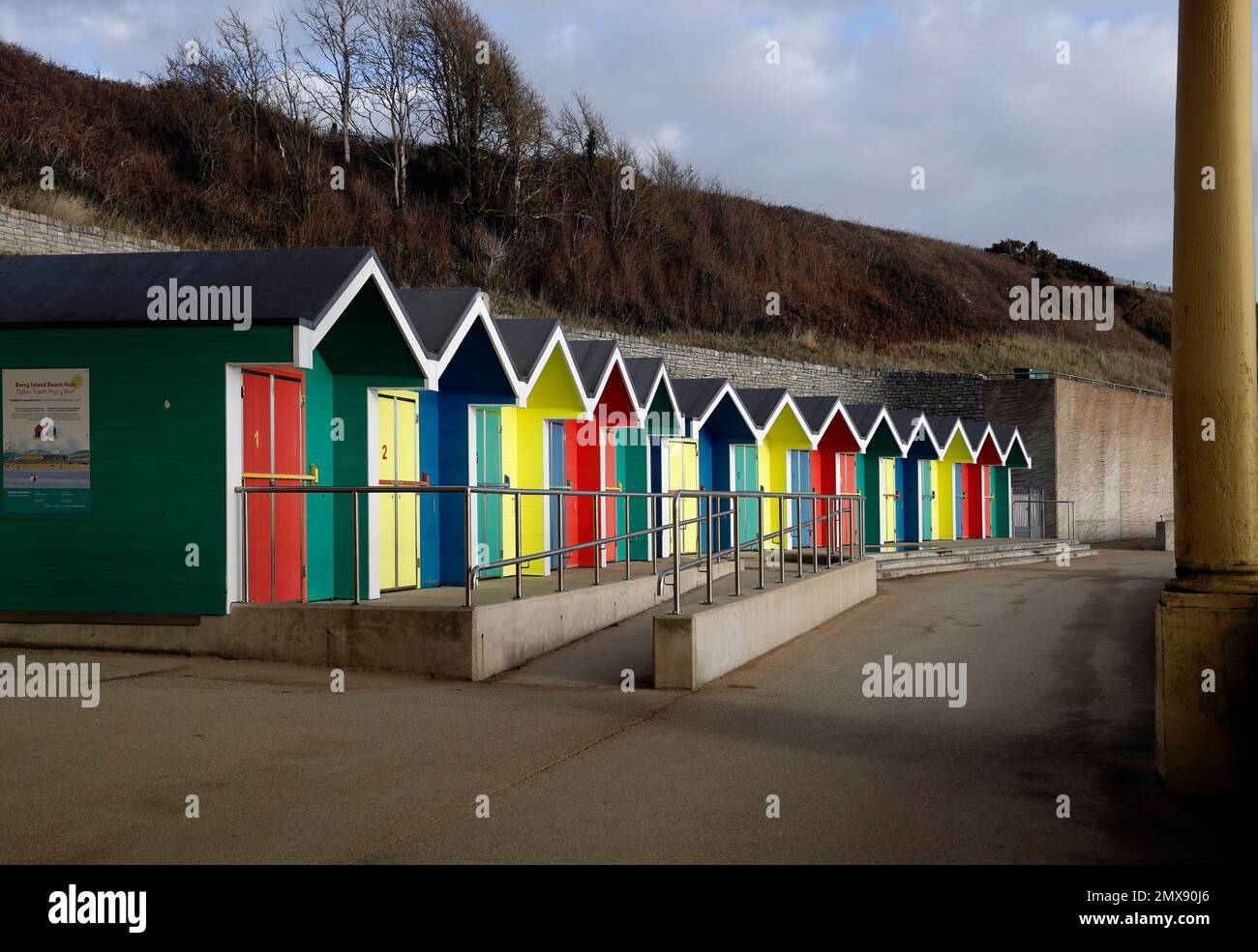 Colourful brightly painted wooden beach huts at Barry Island, locked up out of season. January ...