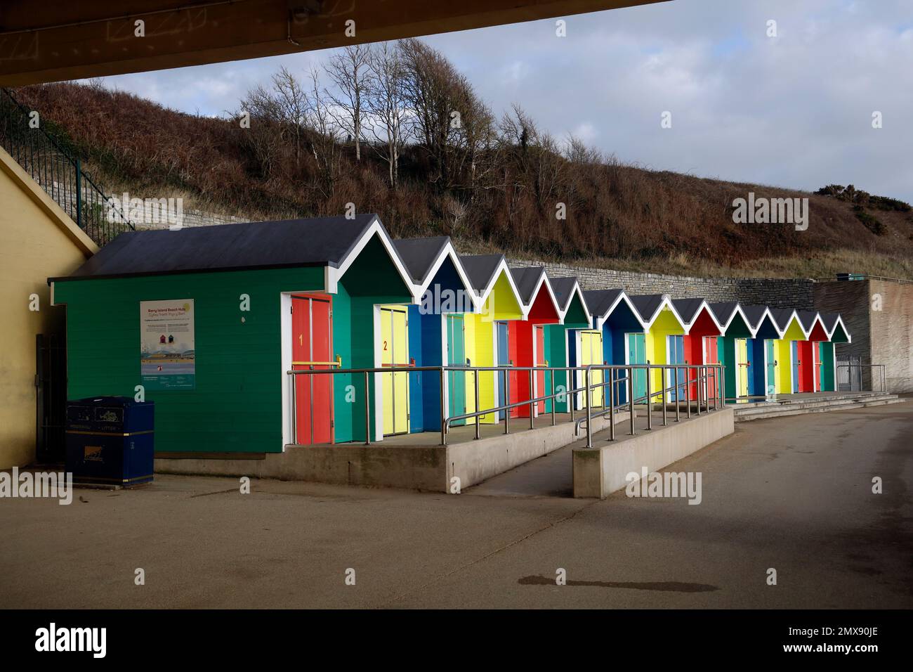 Colourful brightly painted wooden beach huts at Barry Island, locked up out of season. January ...