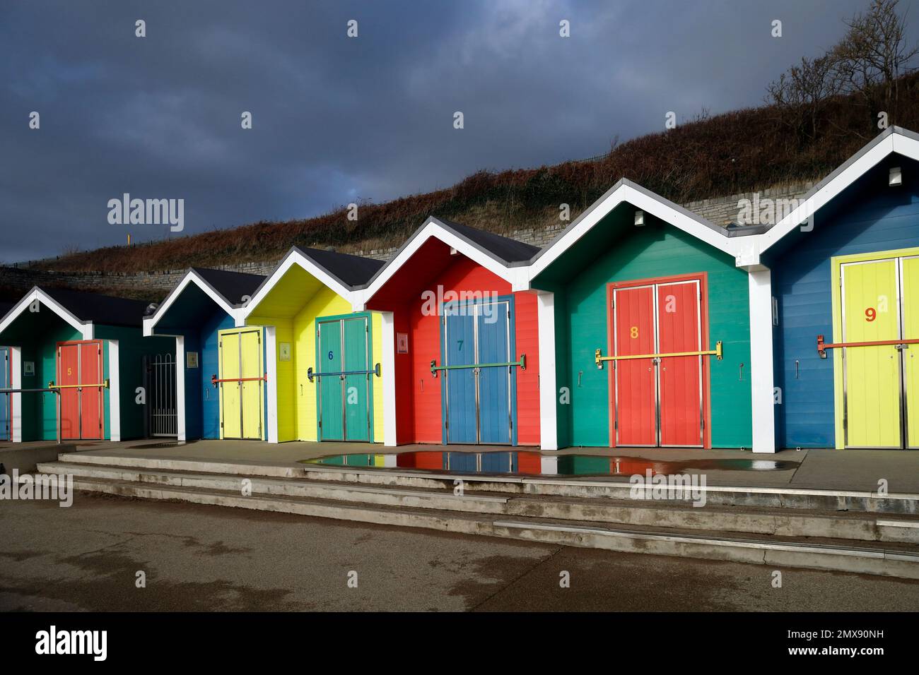 Colourful brightly painted wooden beach huts at Barry Island, locked up out of season. January ...
