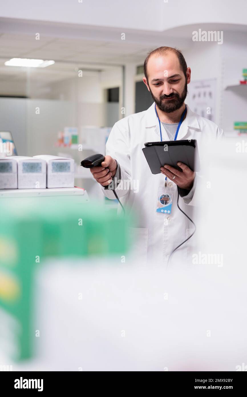 Pharmacist checking medication list on tablet computer while scanning ...
