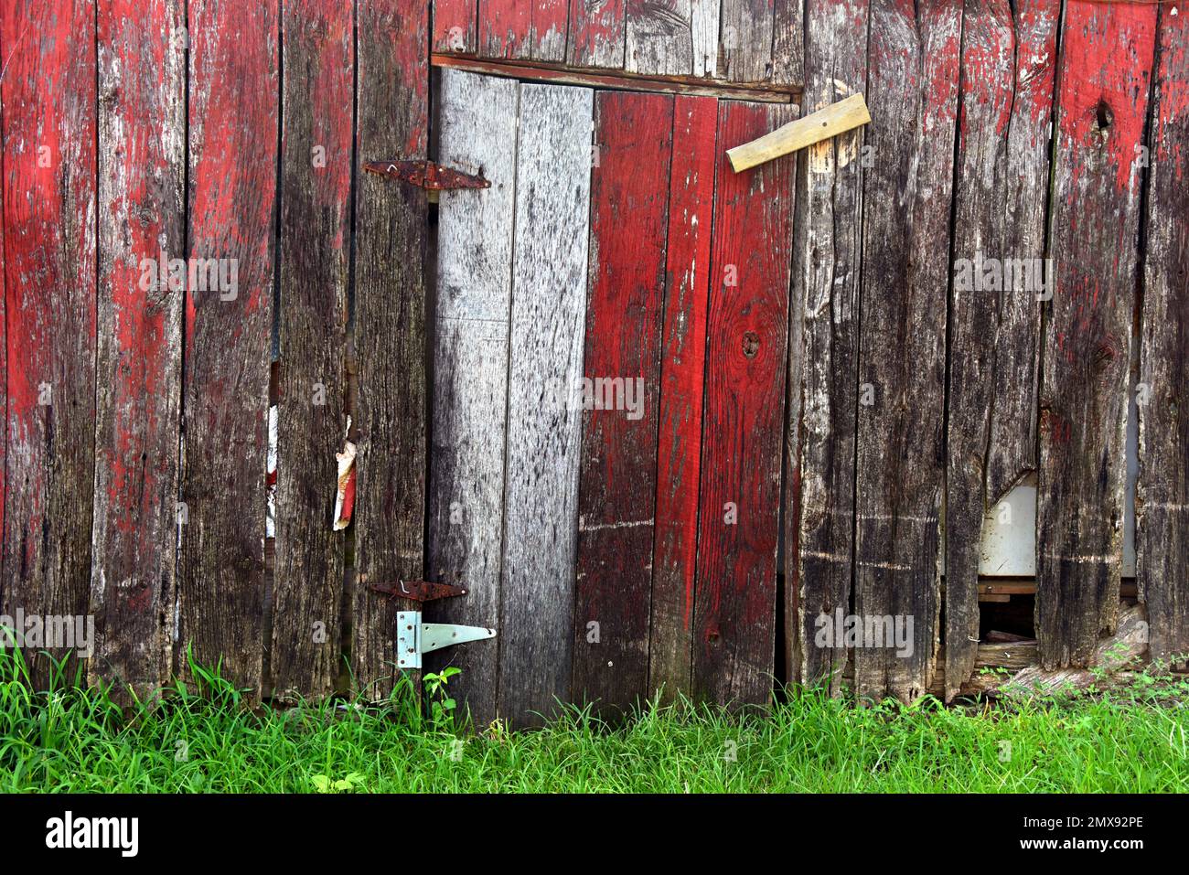 Old barn door is shut and held in place with wooden latch and rusty ...