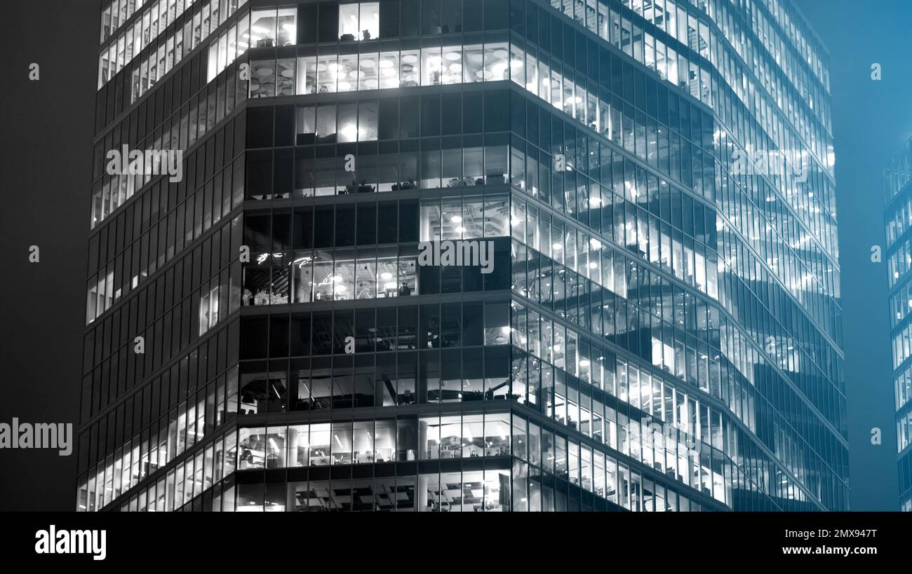 Pattern of office buildings windows illuminated at night. Lighting with ...