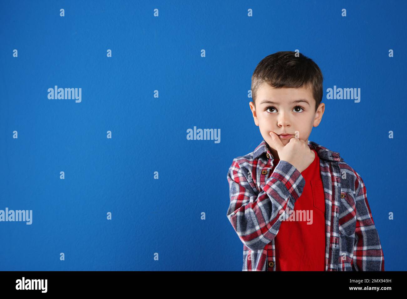 Thoughtful little boy on blue background, space for text Stock Photo ...