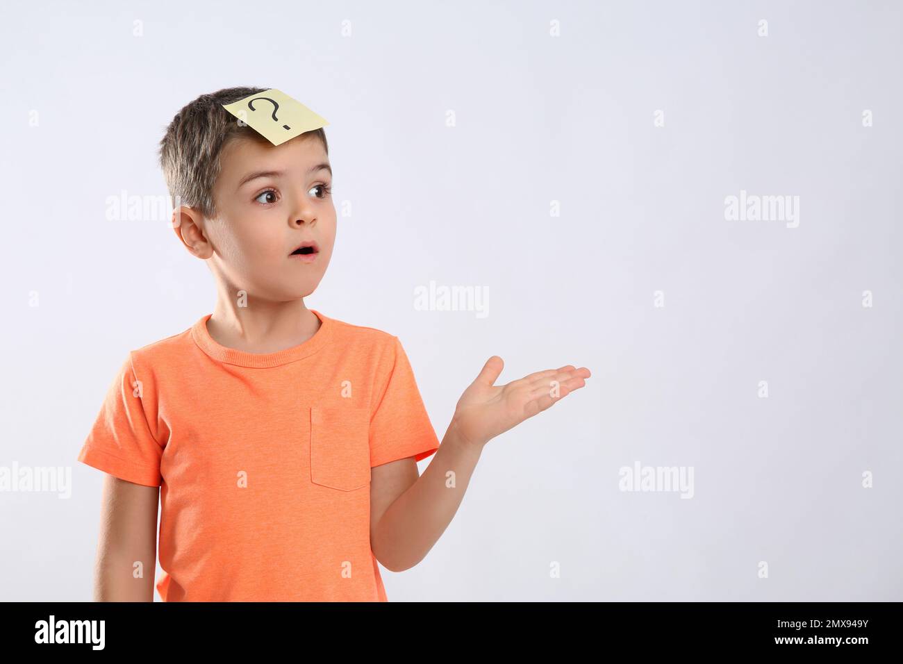 Emotional little boy with question mark on white background Stock Photo ...