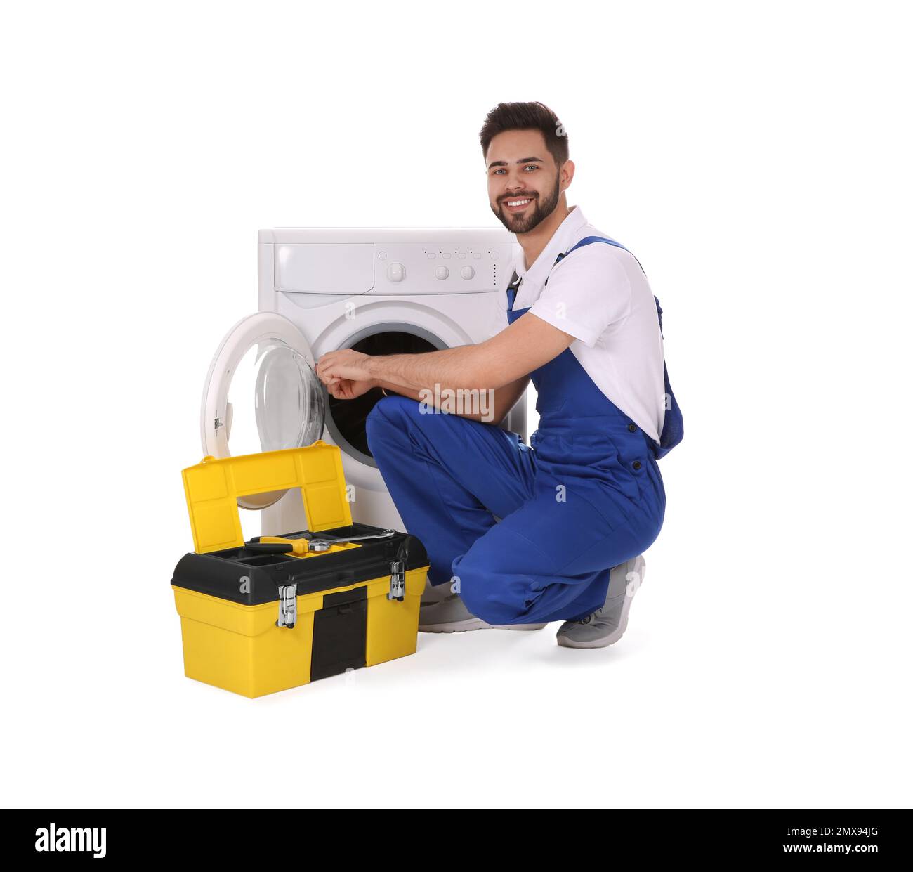 Plumber repairing washing machine on white background Stock Photo - Alamy