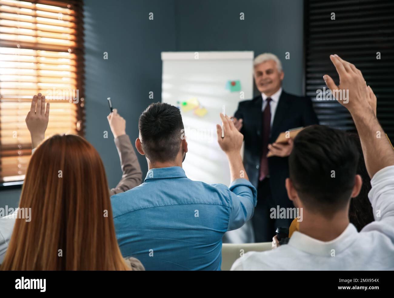People raising hands to ask questions at seminar in office Stock Photo ...