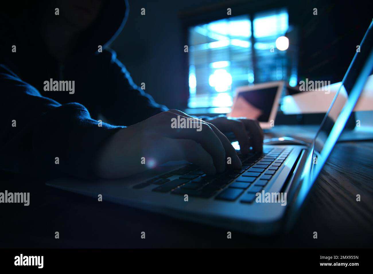 Hacker with laptop in dark room, closeup. Cyber crime Stock Photo - Alamy