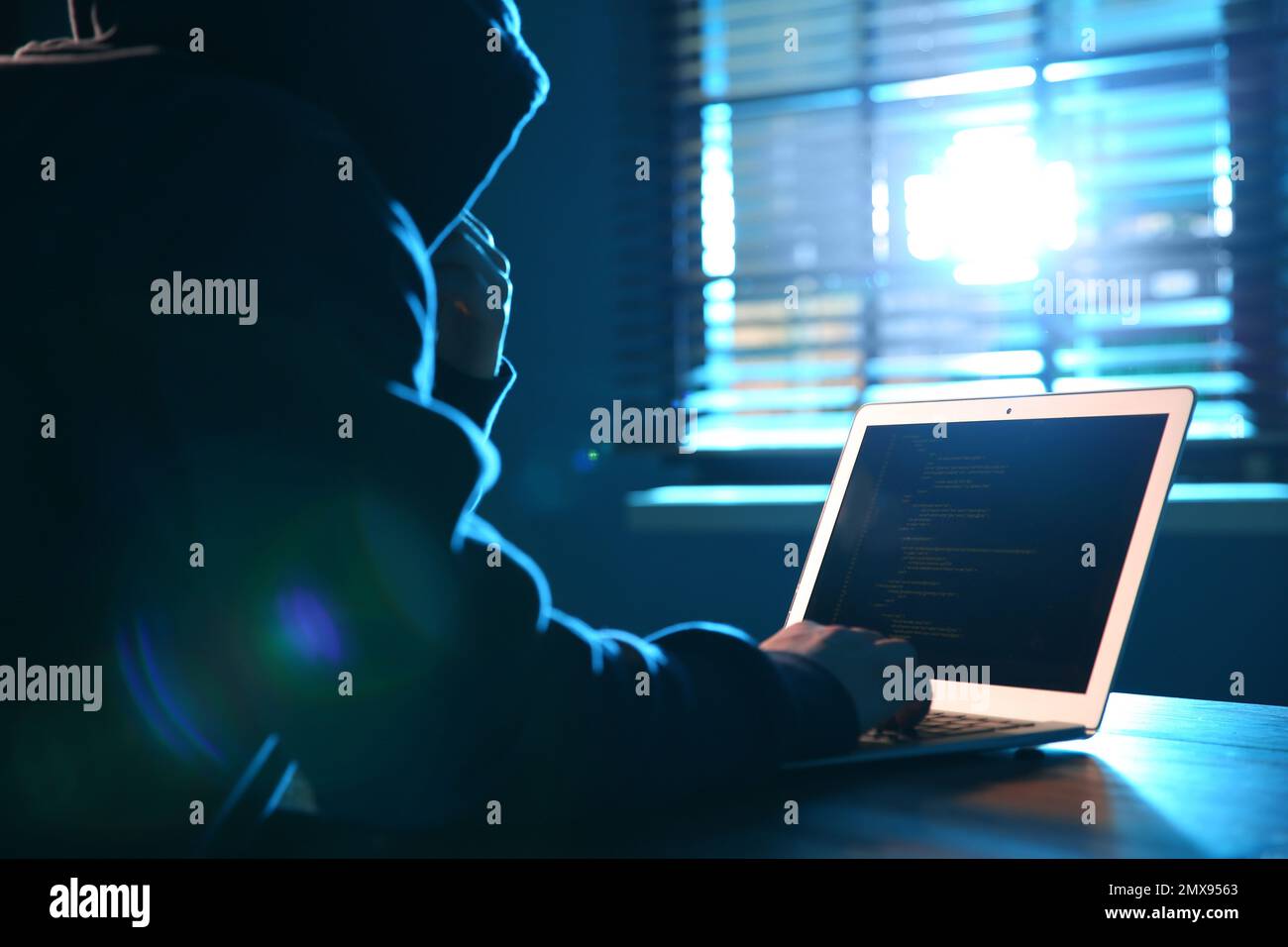 Hacker with laptop in dark room. Cyber crime Stock Photo - Alamy