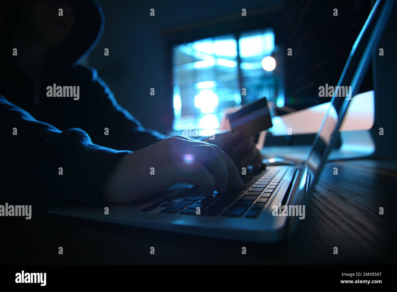 Hacker with credit card and laptop in dark room. Cyber crime Stock ...