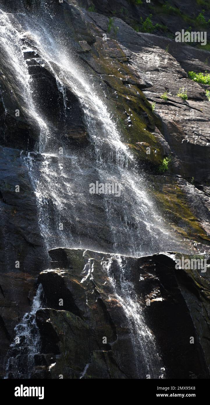Closeup image shows thin spray of cascade falling down the rock face at ...