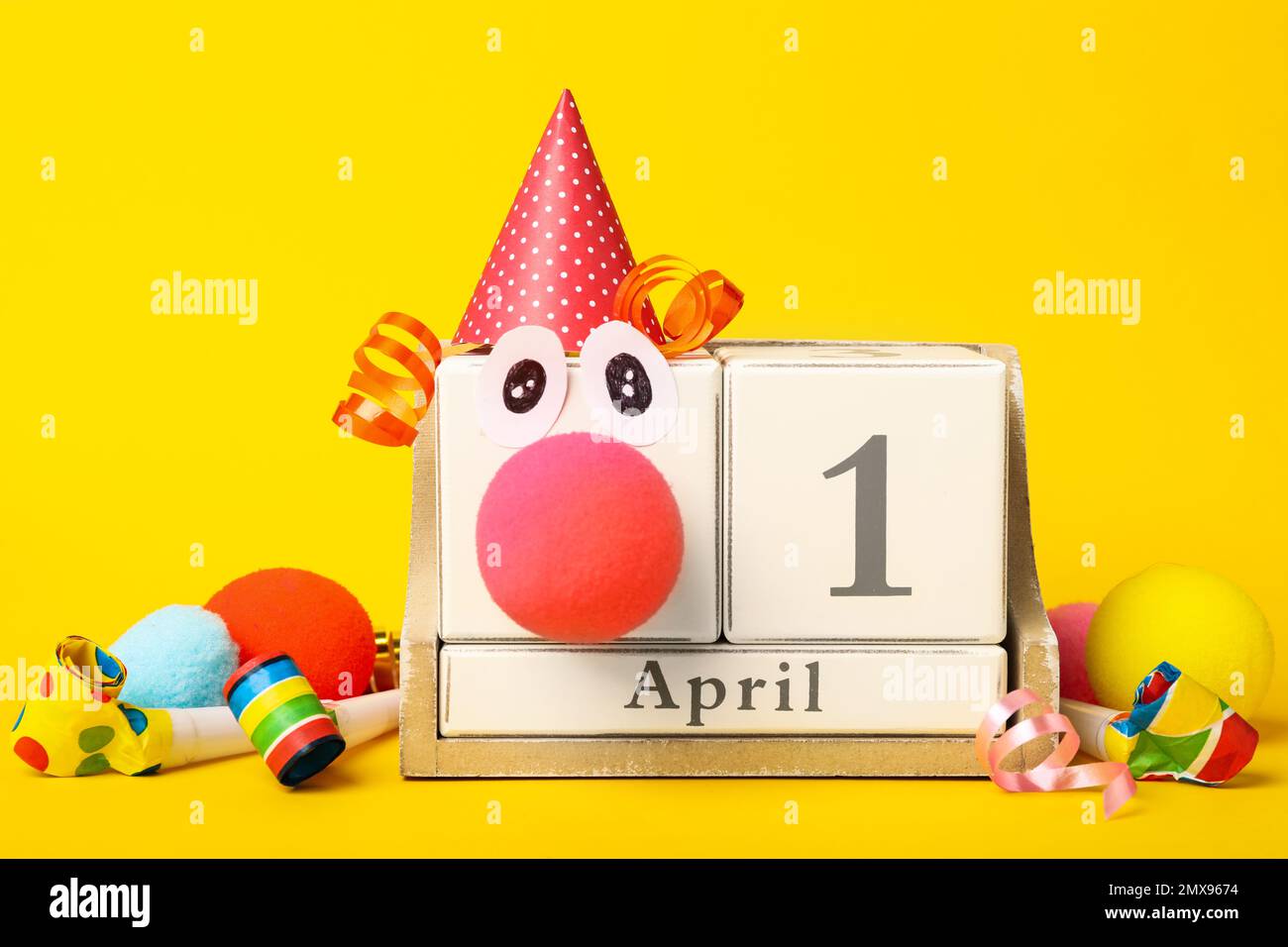Wooden block calendar with clown face and party decor on yellow ...