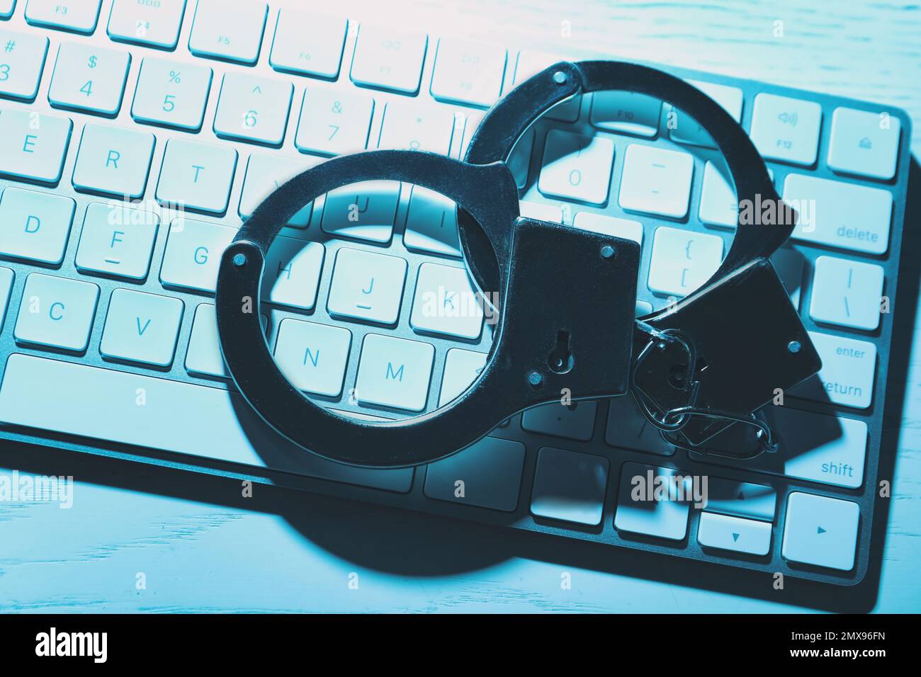 Handcuffs and computer keyboard on table, top view. Cyber crime Stock ...