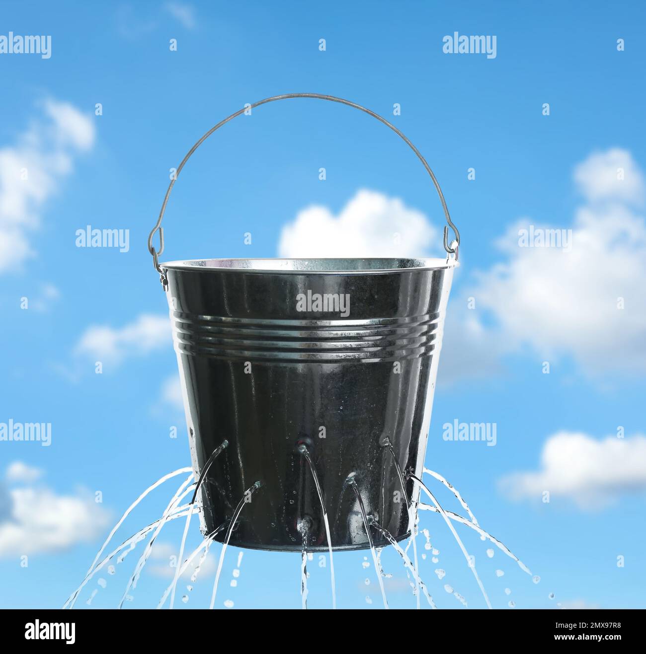 Leaky bucket with water against blue sky Stock Photo - Alamy