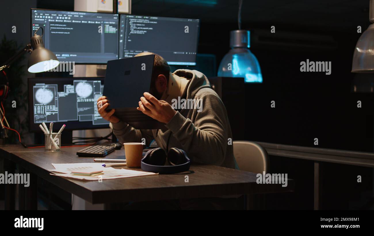 Database admin with neck collar foam working on code developing at night, typing html script on ...