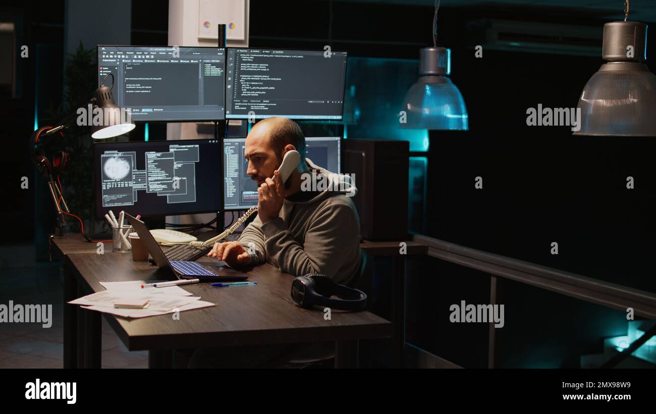 Male app developer answering landline phone call late at night, talking ...