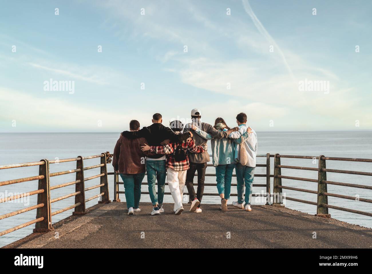 A diverse group of young friends come together in a tight embrace ...