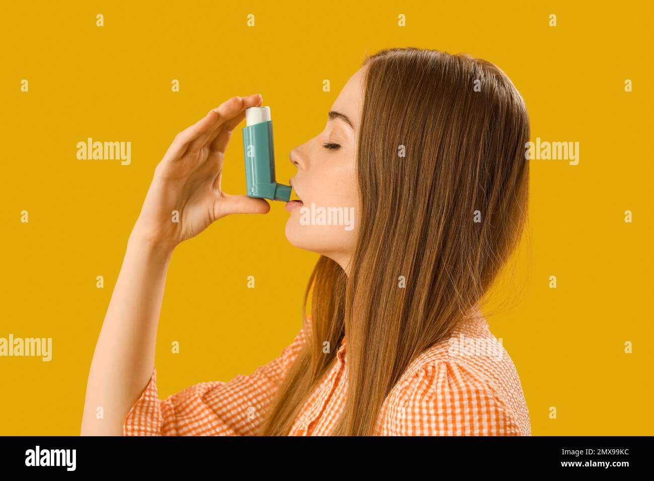 Sick young woman with inhaler on yellow background Stock Photo - Alamy