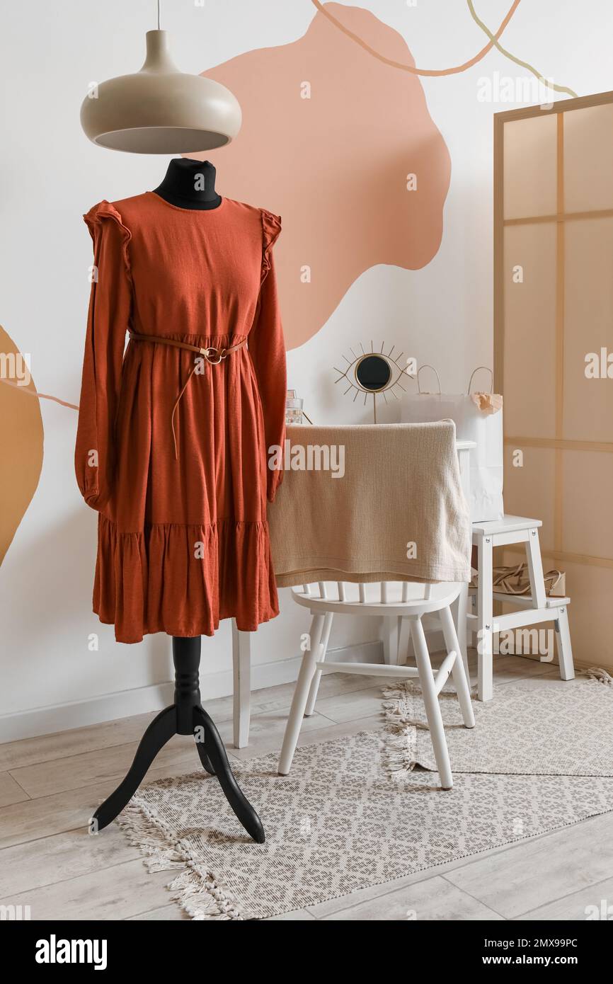 Interior of fashion designer's studio with mannequin in red dress and ...