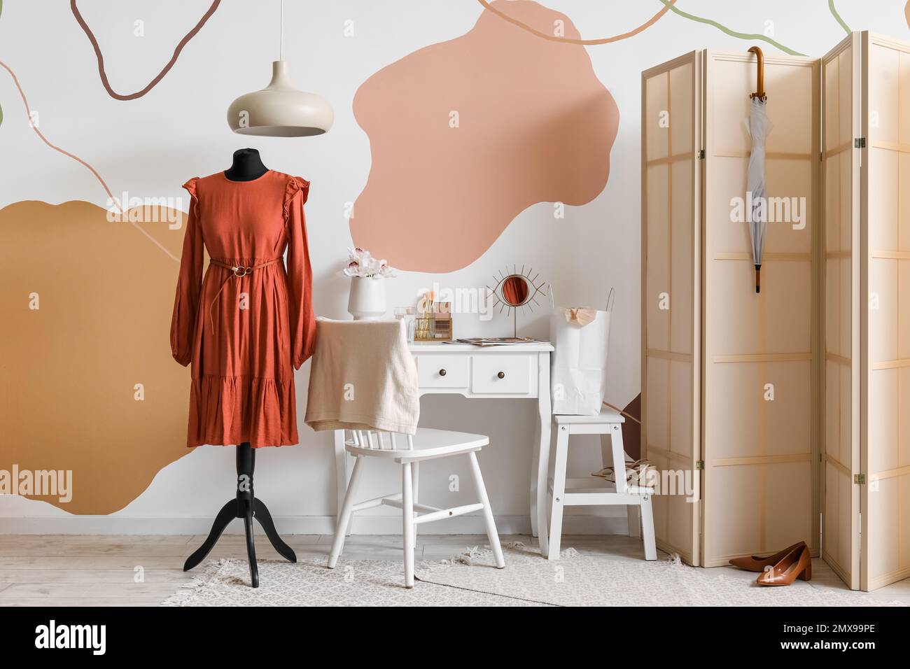 Interior of fashion designer's studio with mannequin in red dress and ...