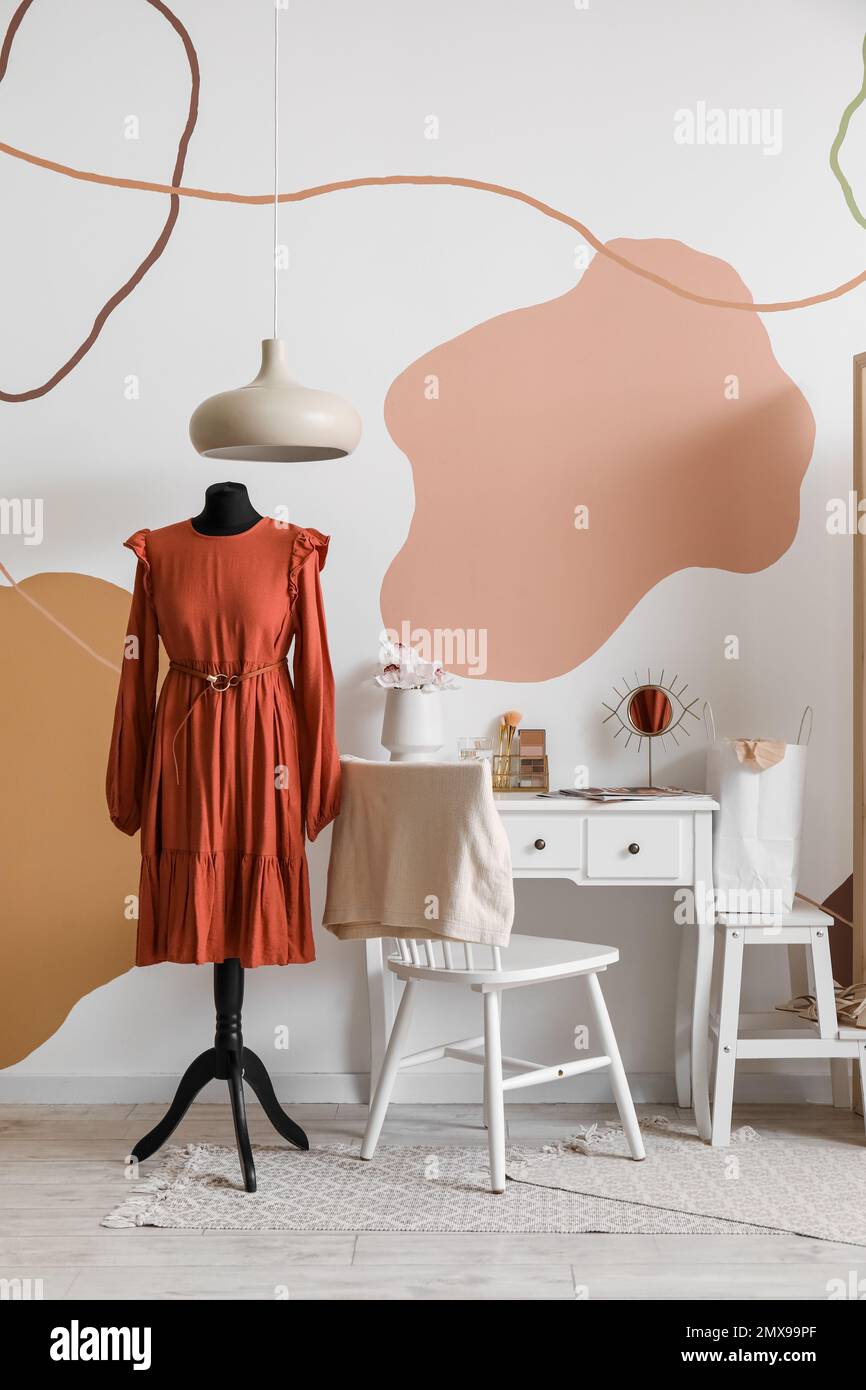 Interior of fashion designer's studio with mannequin in red dress and ...