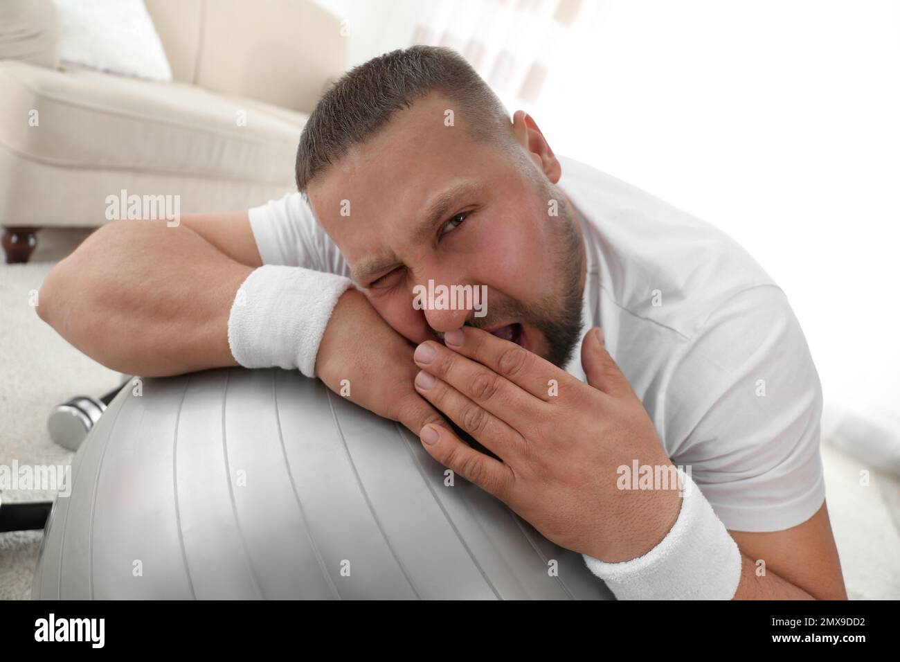 Lazy overweight man lying on exercise ball at home Stock Photo - Alamy