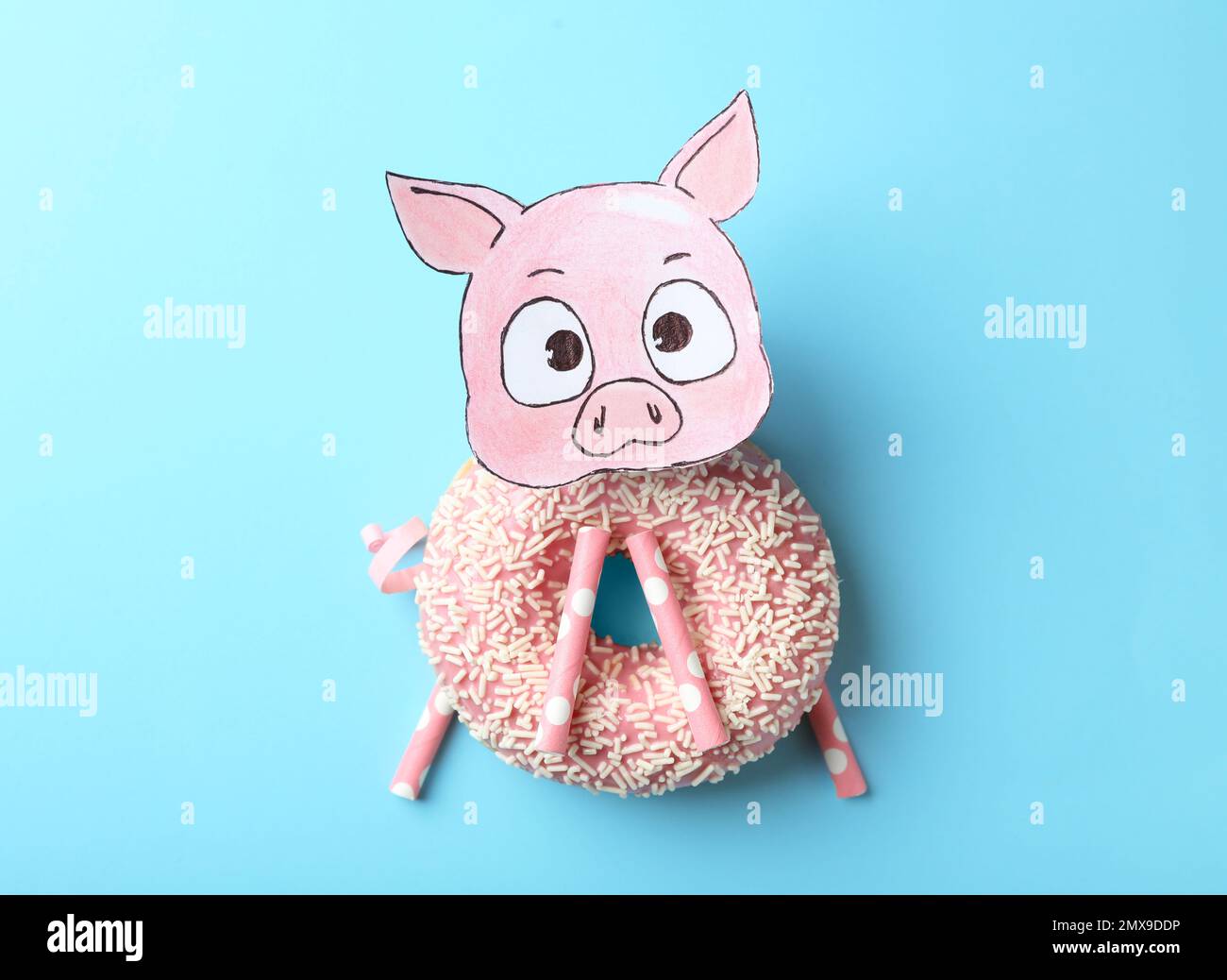 Funny pig made with donut and straws on light blue background, flat lay ...