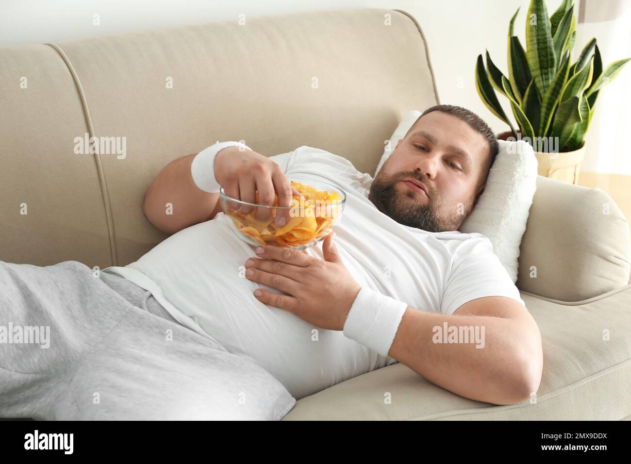 Fat man eating chips hi-res stock photography and images - Alamy