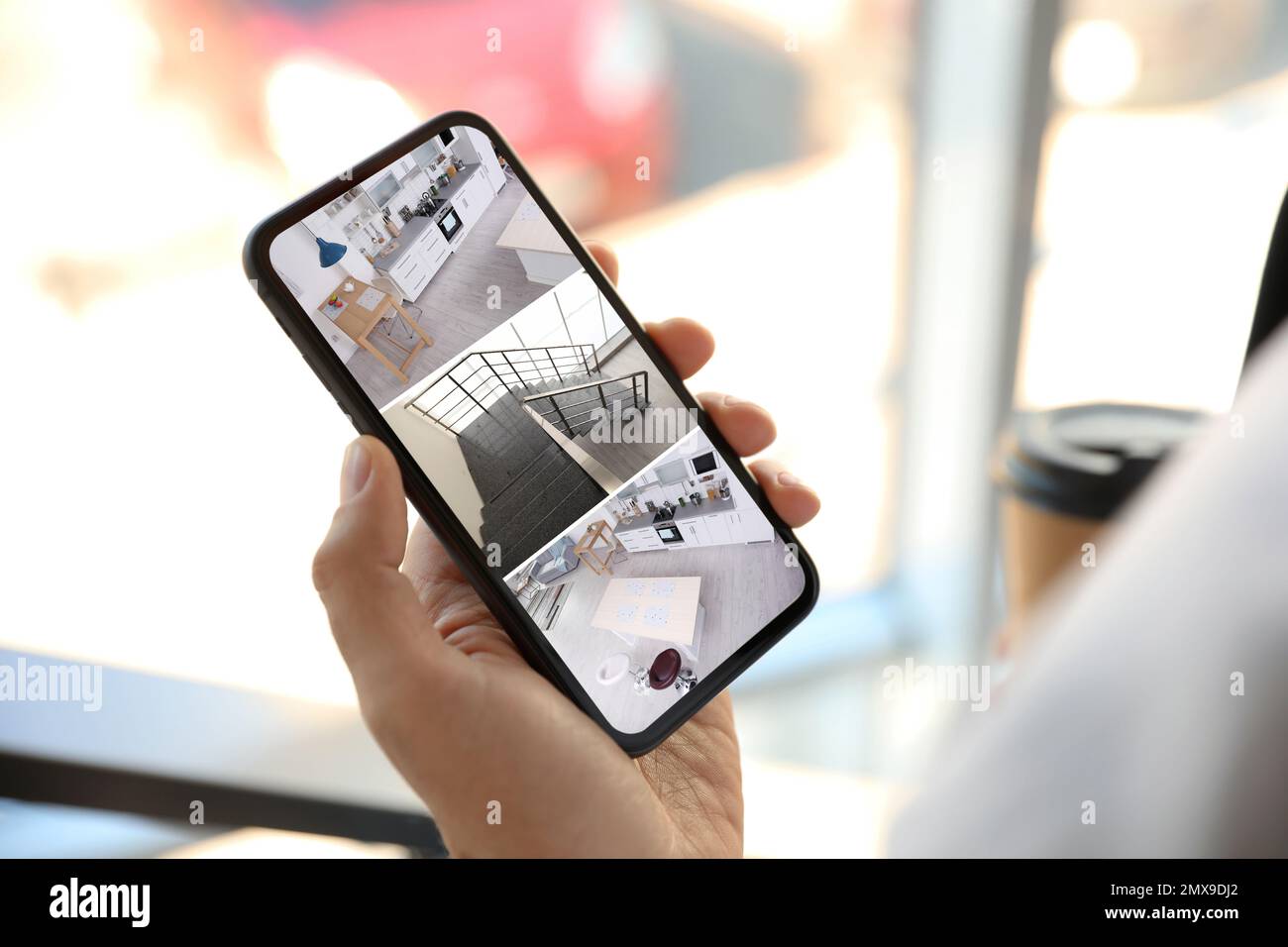 Woman monitoring modern cctv cameras on smartphone indoors, closeup ...