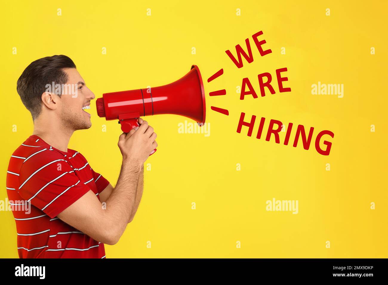 Man with megaphone and phrase WE ARE HIRING on yellow background ...