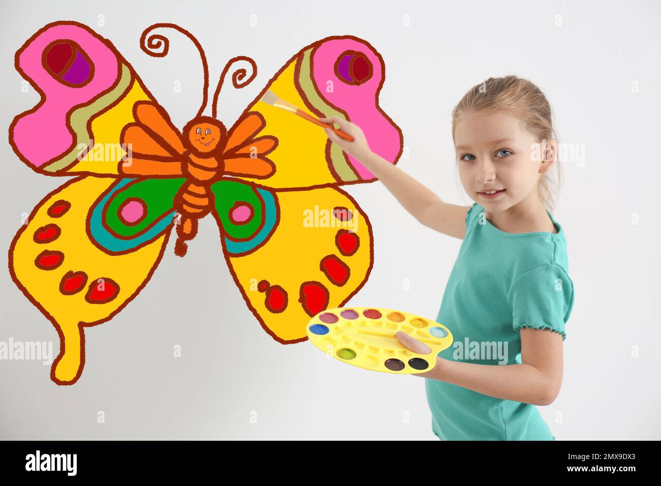 Cute child drawing butterfly on white wall indoors Stock Photo - Alamy