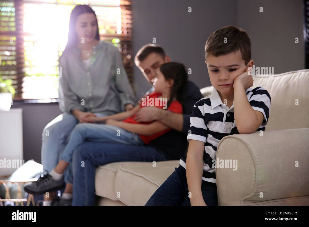 Unhappy little boy feeling jealous while parents spending time with his ...