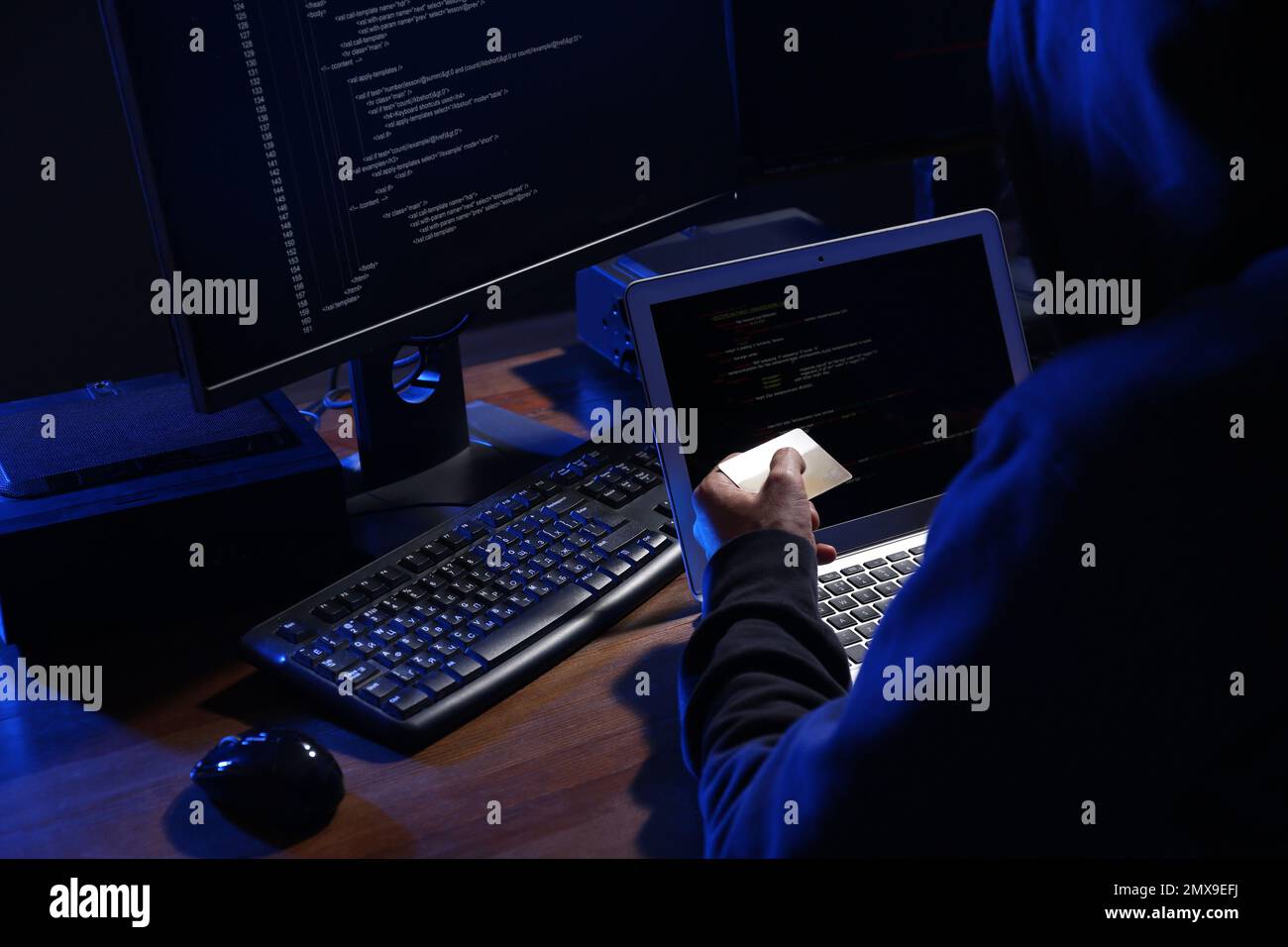 Hacker with computers and credit card in dark room. Cyber crime Stock ...