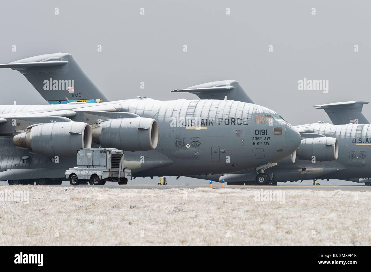 A snow-covered C-17 Globemaster III sits on the flight line at Dover ...
