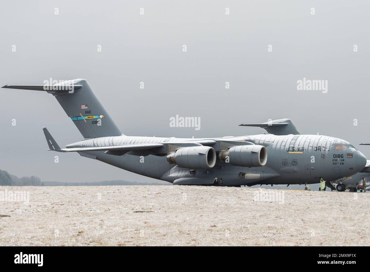 A snow-covered C-17 Globemaster III sits on the flight line at Dover ...