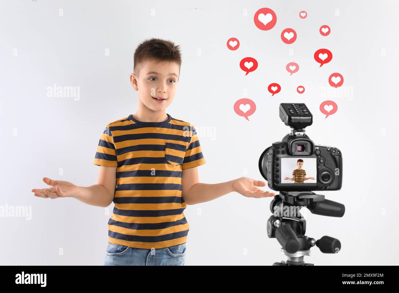 Cute little blogger recording video on white background Stock Photo - Alamy