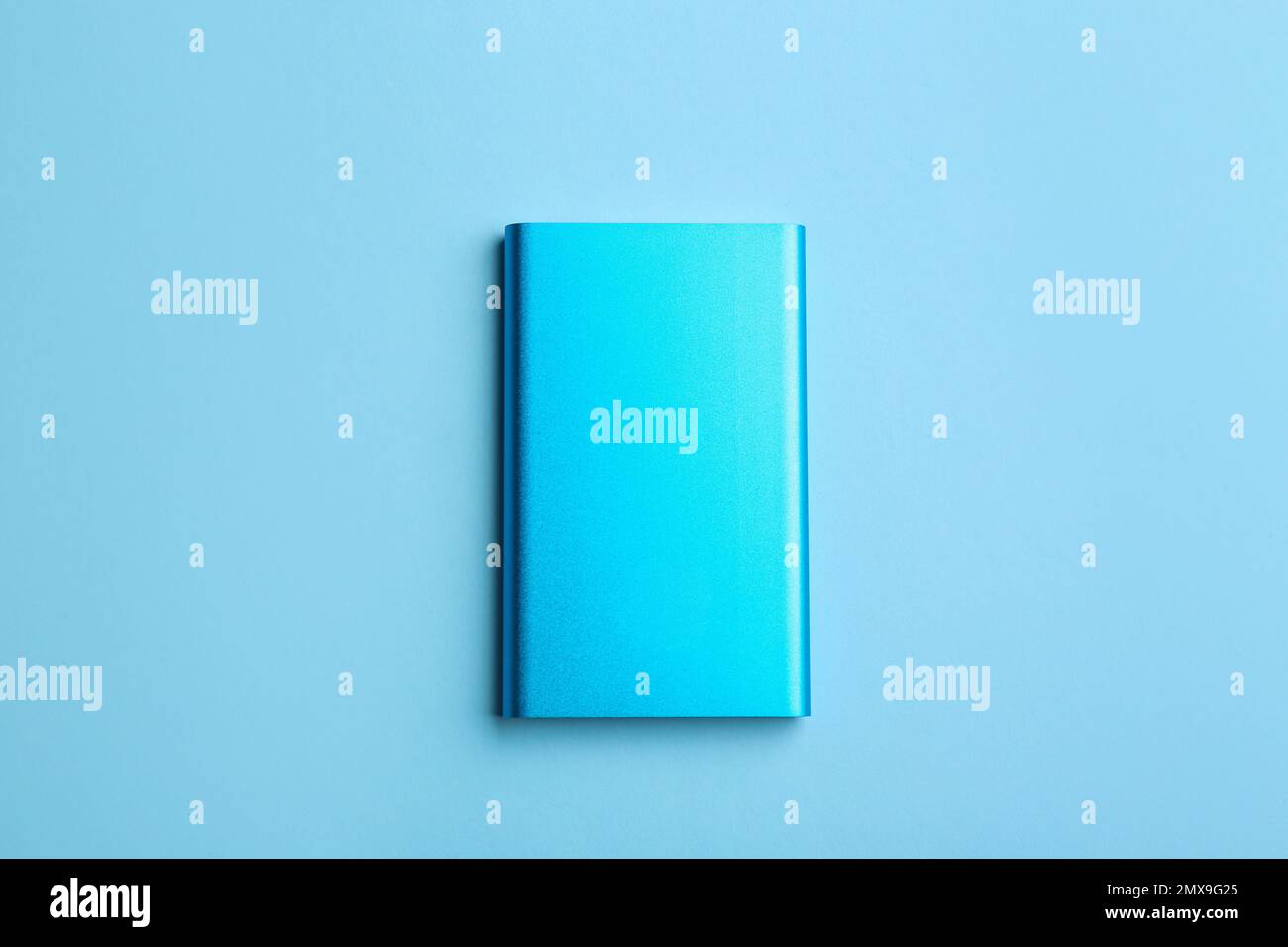 Modern external portable charger on light blue background, top view ...