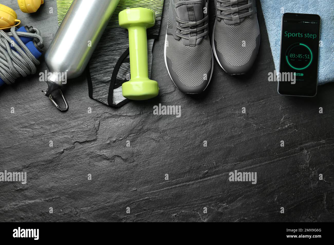 Smartphone with step counter app and fitness accessories on black ...